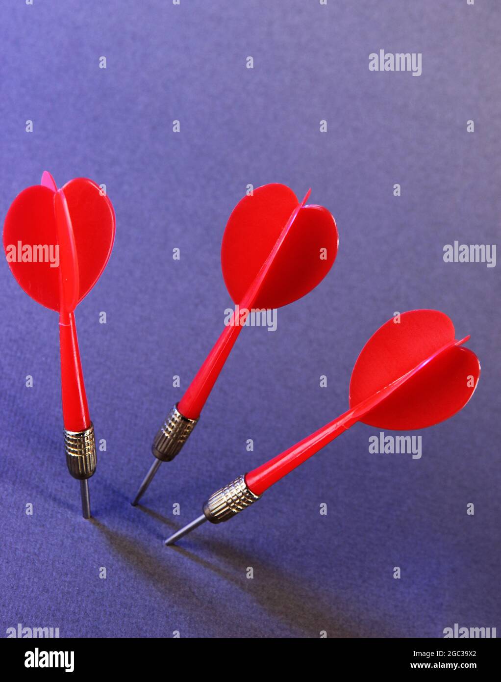 Darts on purple background Stock Photo - Alamy