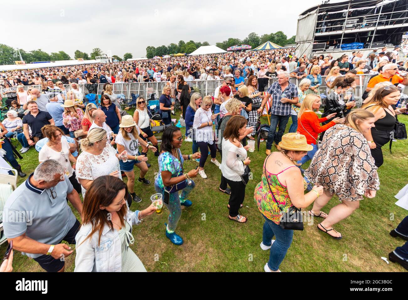 Music festival fans dancing to the music at a large concert soon after ...