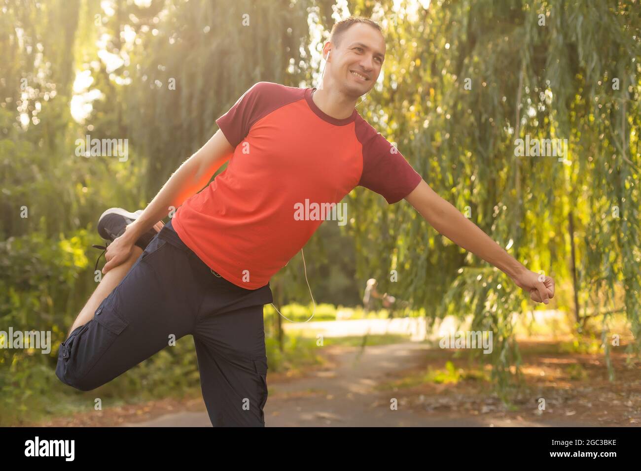 Stretching after jogging. happy man after jogging Stock Photo - Alamy