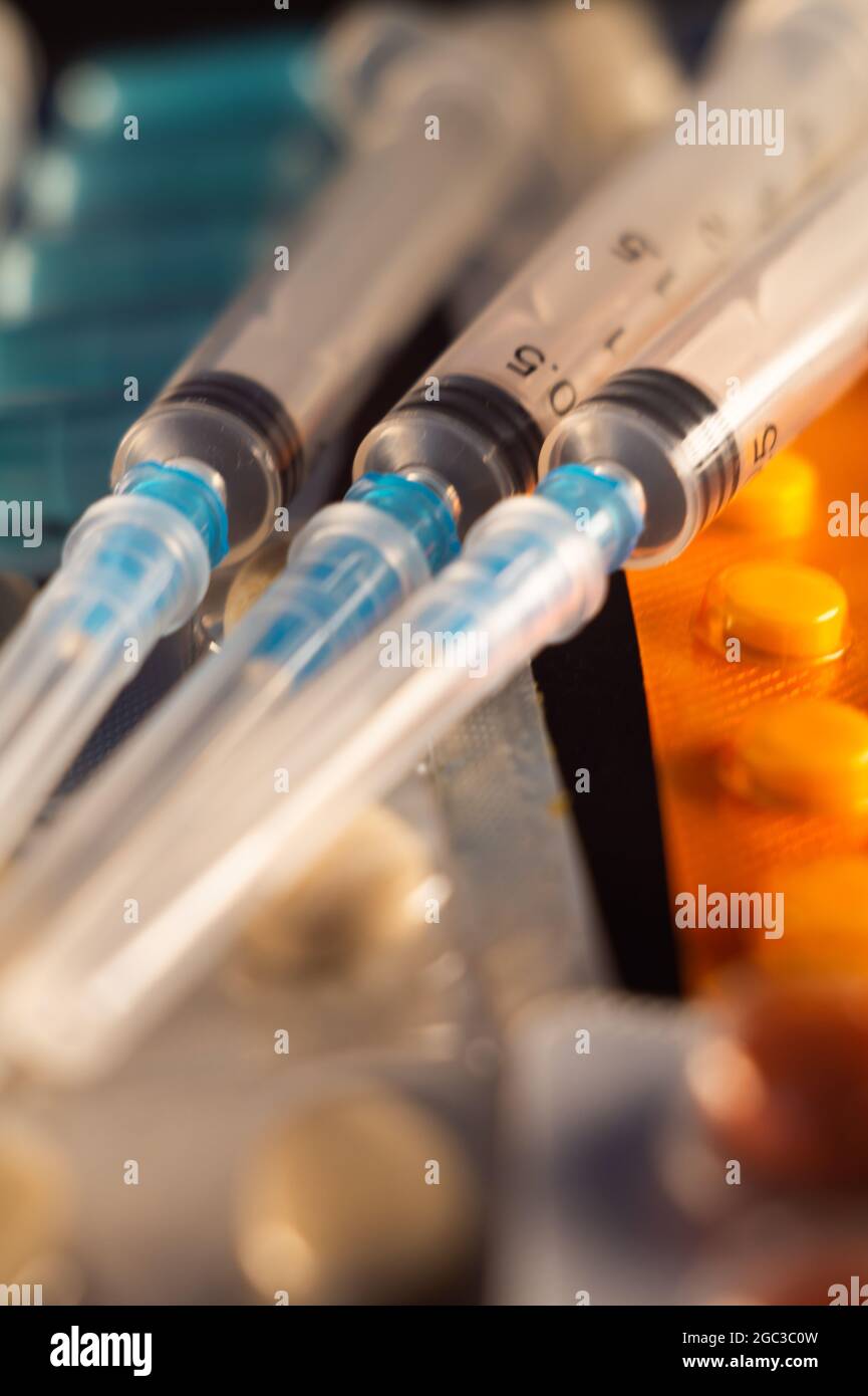 Vertical shot of pharmaceutical capsules, pills and syringes Stock ...