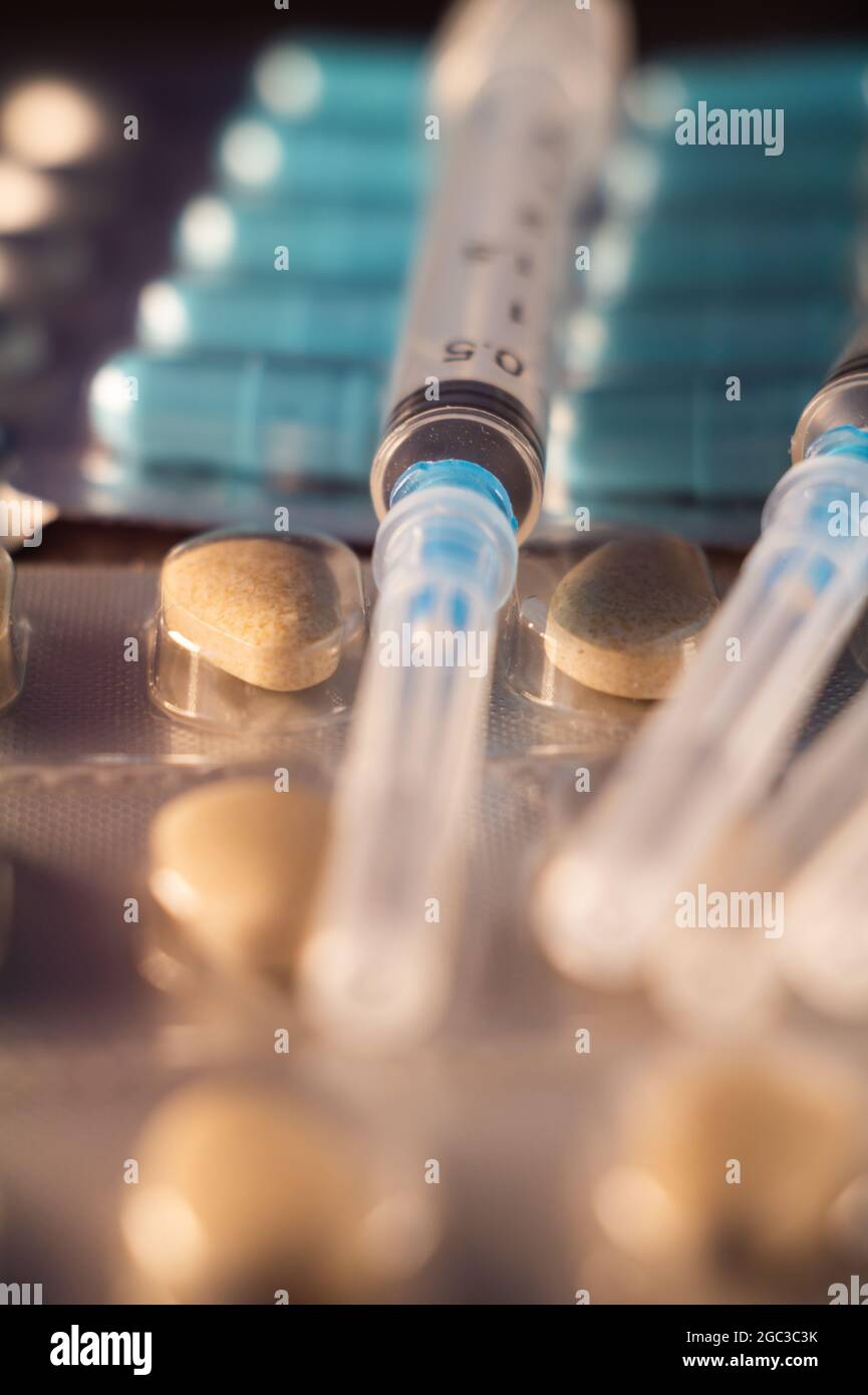 Vertical shot of pharmaceutical capsules, pills and syringes Stock ...