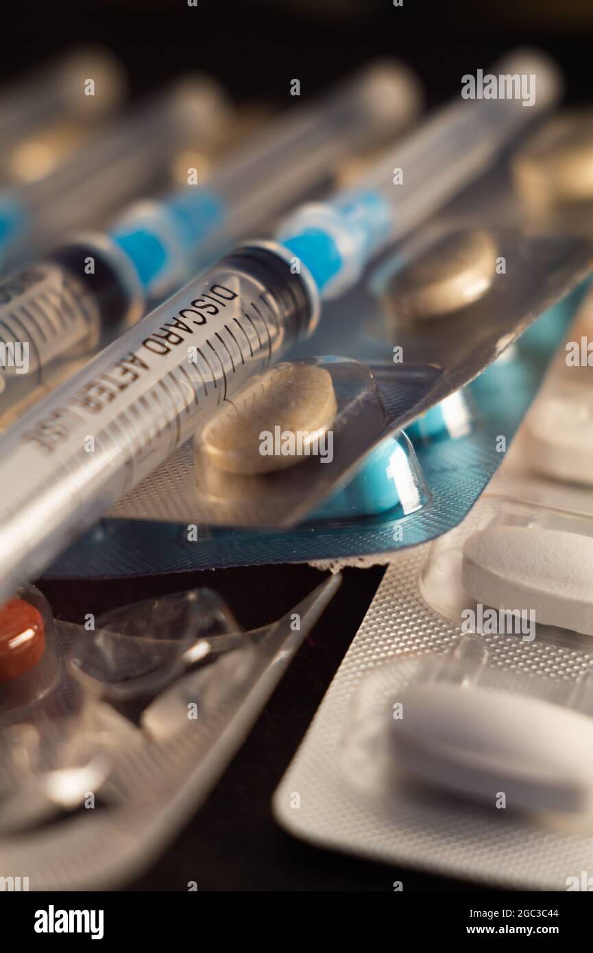 Vertical shot of pharmaceutical capsules, pills and syringes Stock ...