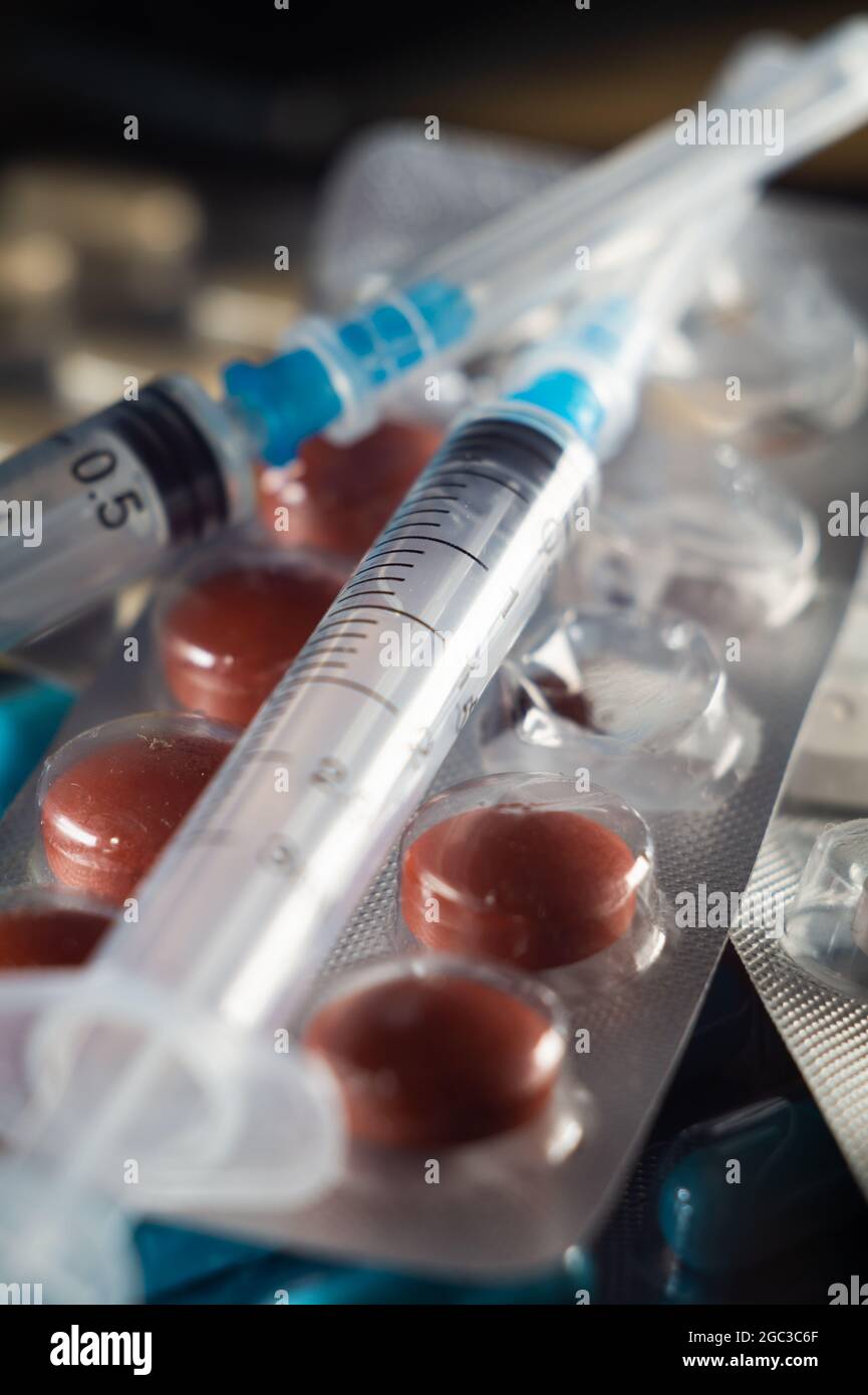 Vertical shot of pharmaceutical capsules, pills and syringes Stock ...