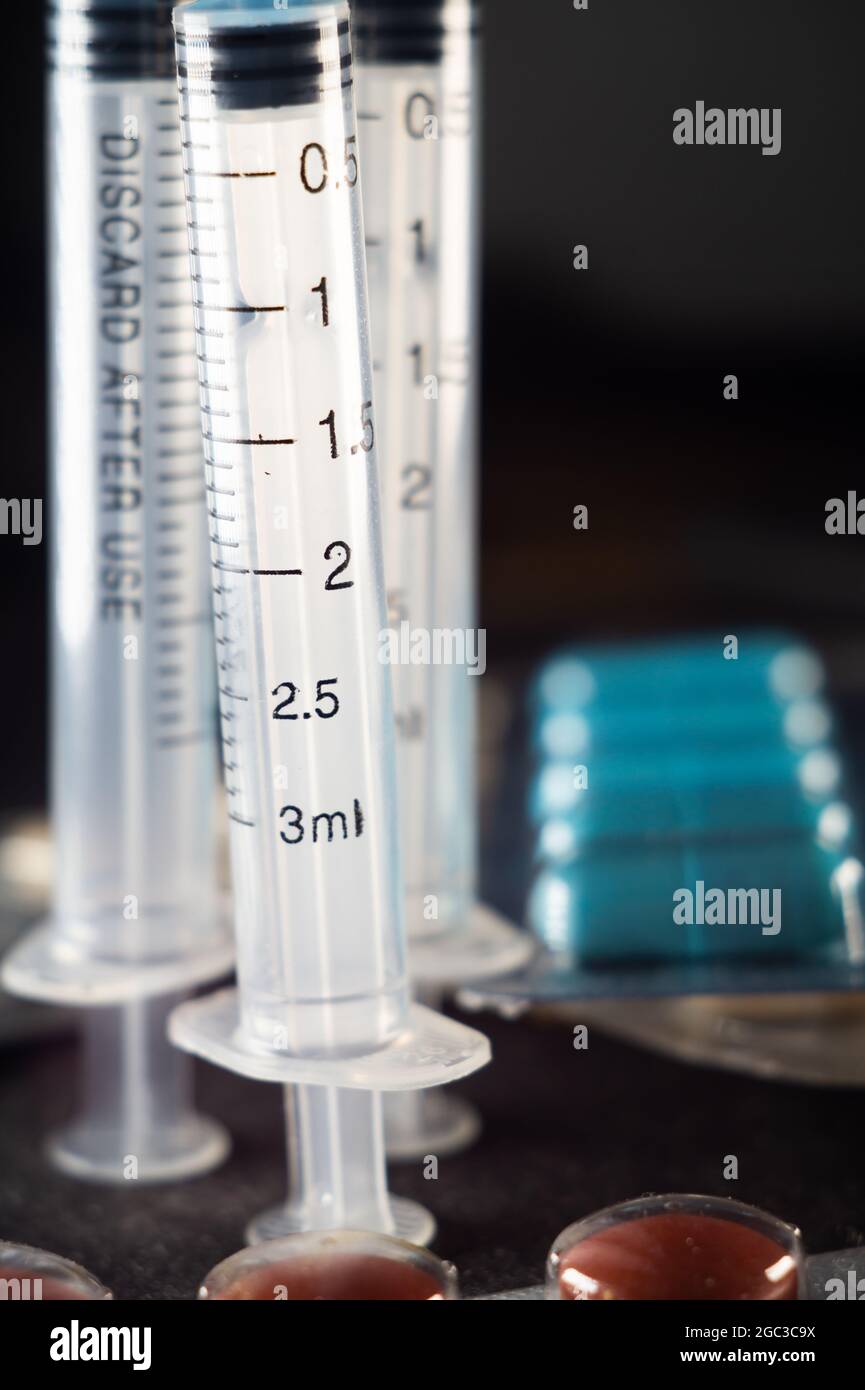 Vertical shot of pharmaceutical capsules, pills and syringes Stock ...