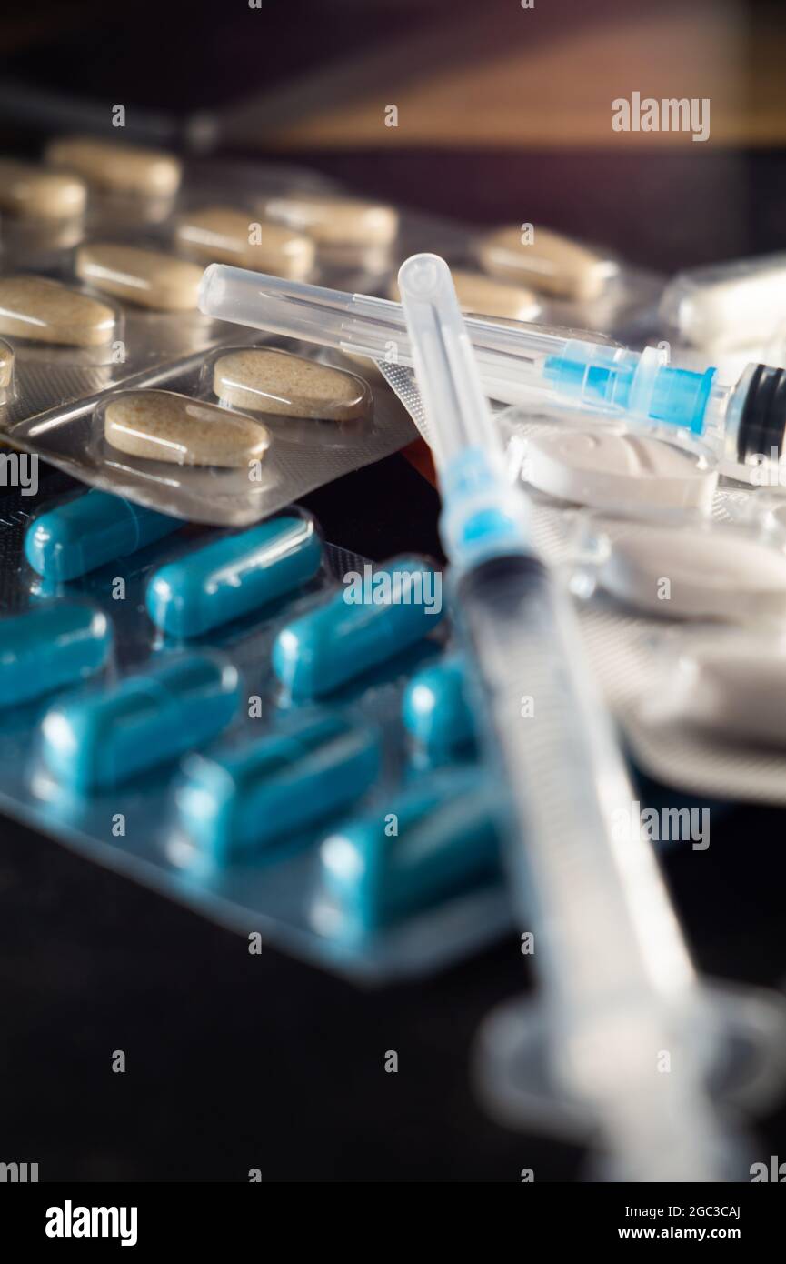 Vertical shot of pharmaceutical capsules, pills and syringes Stock ...