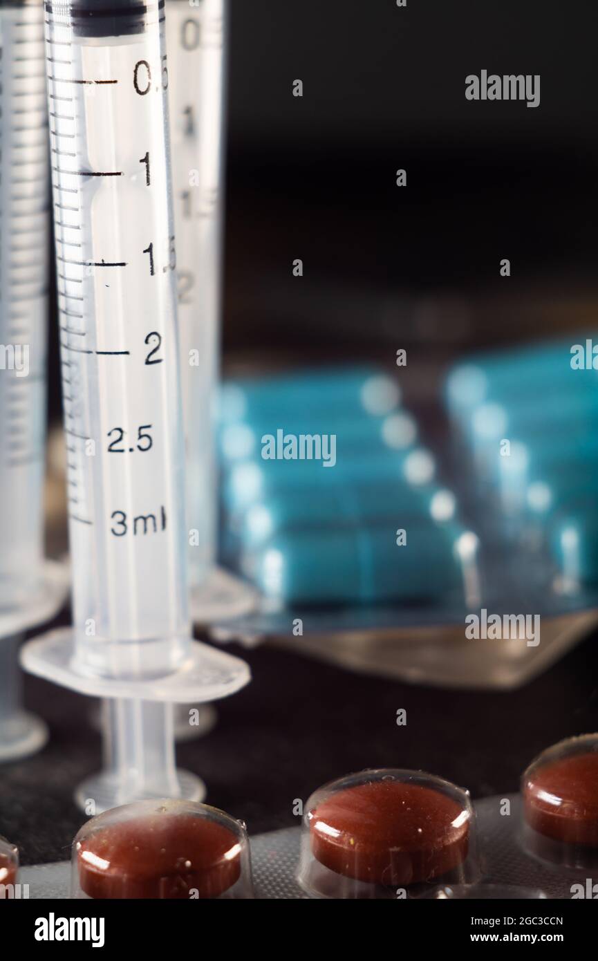 Vertical shot of pharmaceutical capsules, pills and syringes Stock ...