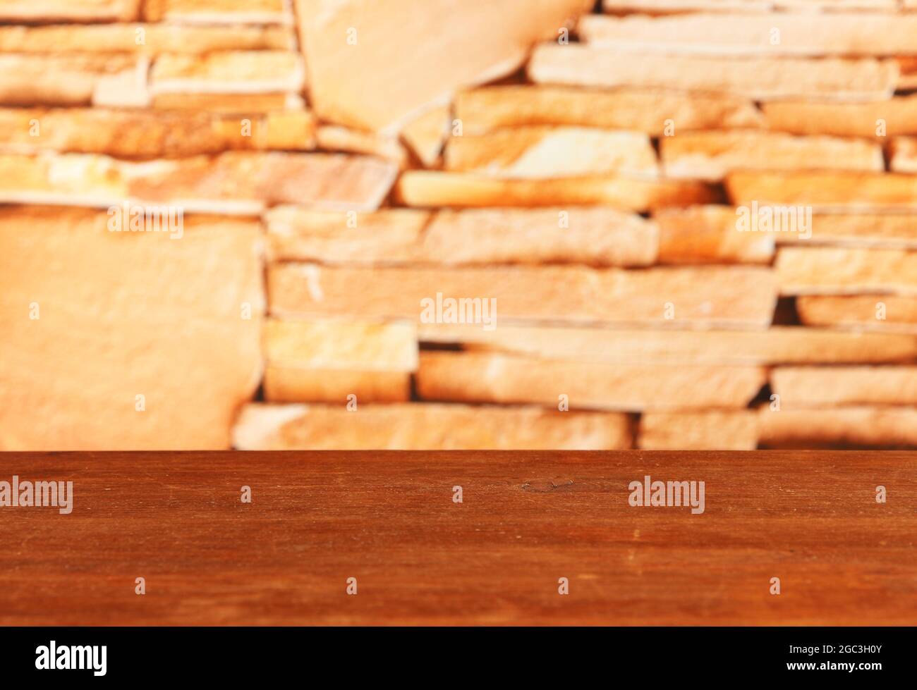 Wooden table on bricks background Stock Photo - Alamy