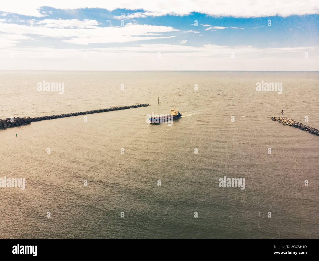 Aerial panoramic view cargo ship entering Klaipeda port in Lithuania ...