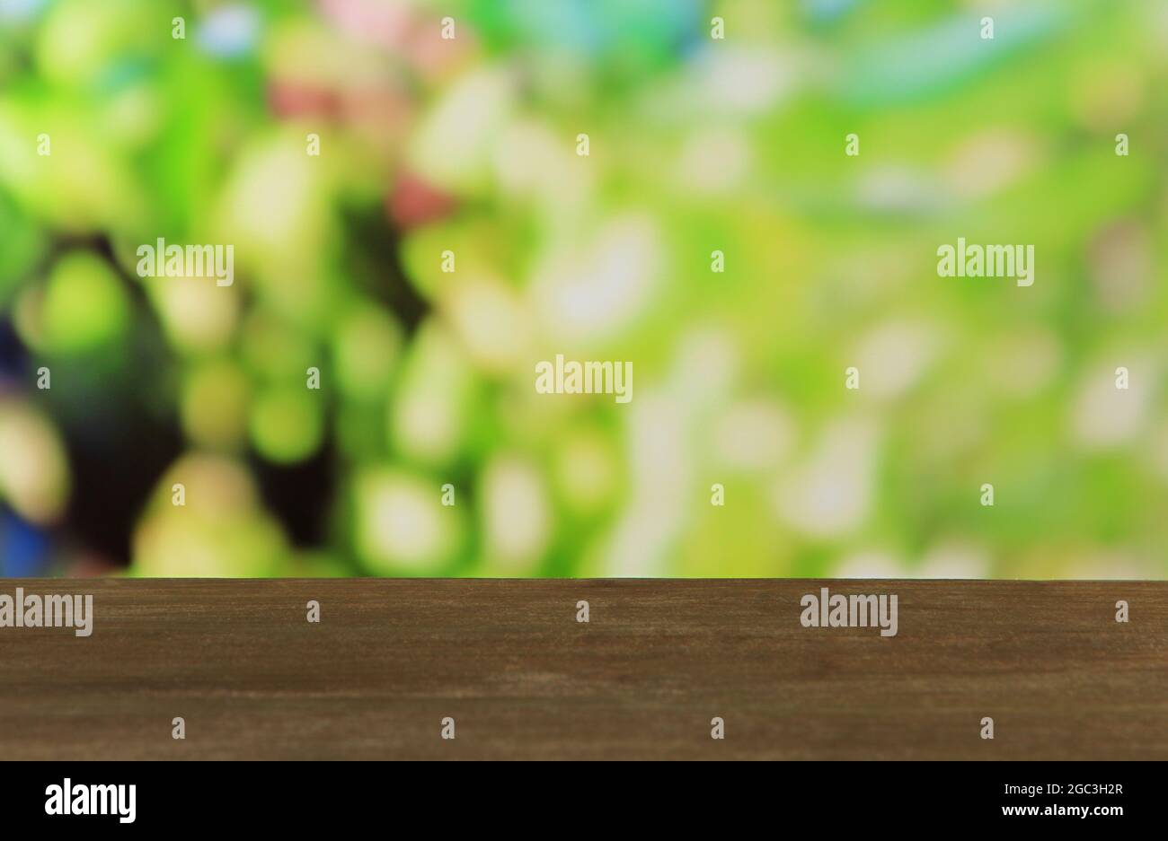 Wooden table on bright green background Stock Photo - Alamy