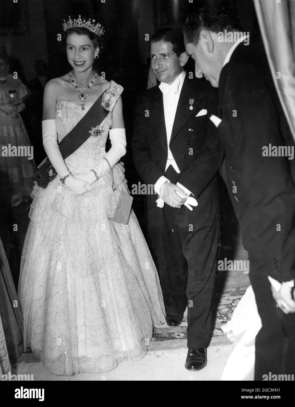 HM Queen Elizabeth II walks along a corridor with the Prime Minister of ...