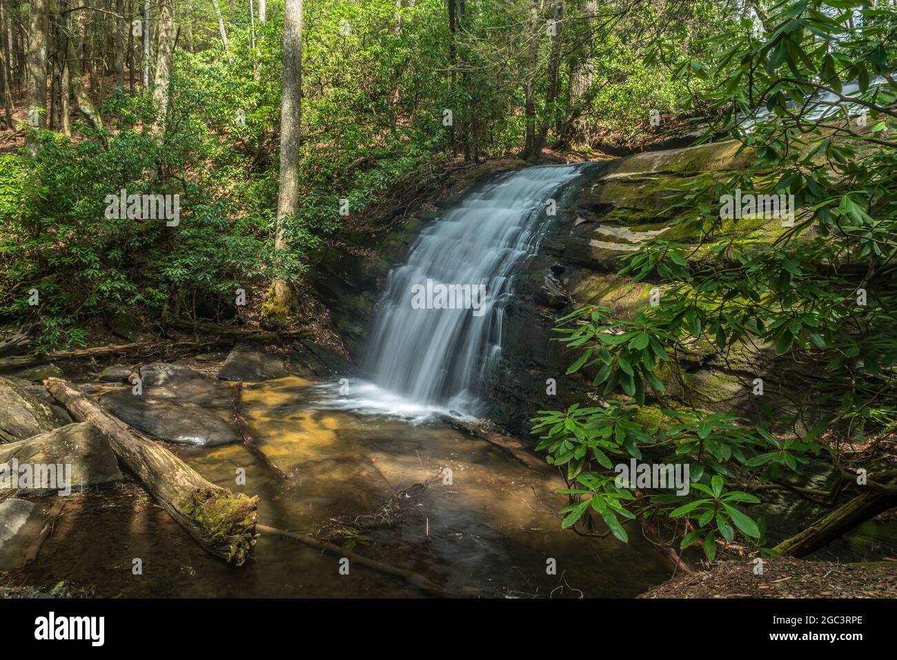 Closeup side view of the waterfall spilling onto the rocks and boulders ...