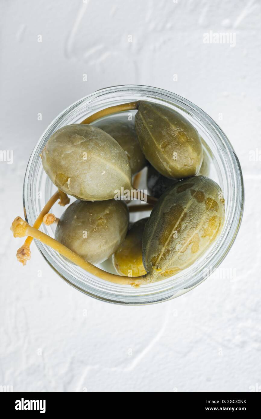 Capers, marinated in oil, on white background, flat lay Stock Photo - Alamy