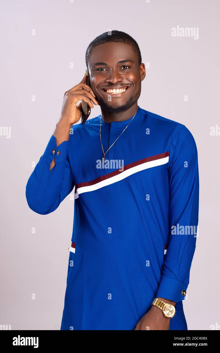 handsome, happy young african man smiling while making a phone call ...