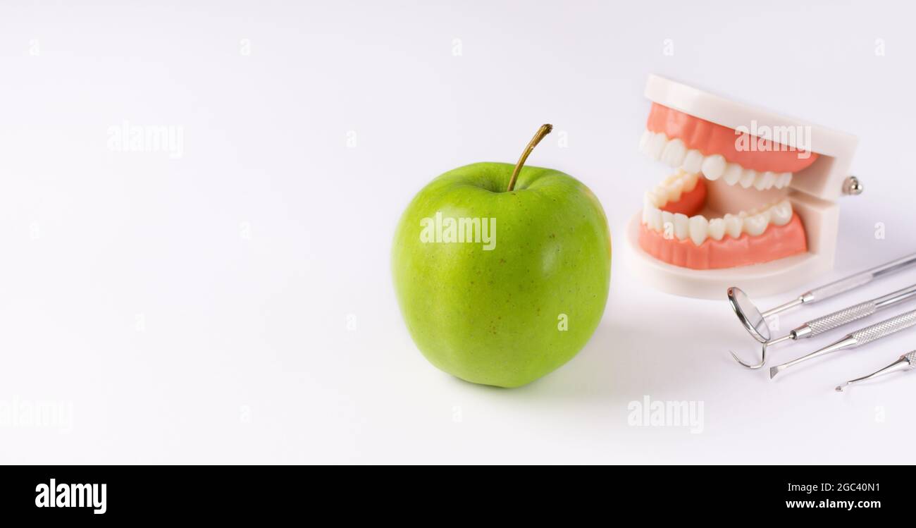 Apple, teeth model and dentist tool on white background. Teeth health ...