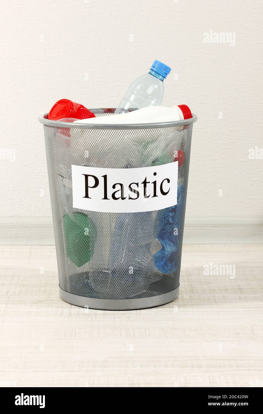 Assorted trash in bucket on room background Stock Photo - Alamy