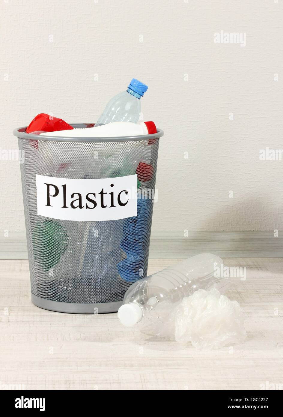 Assorted trash in bucket on room background Stock Photo - Alamy