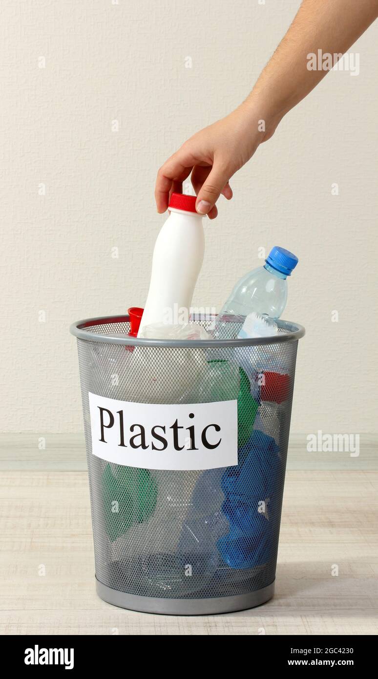 Assorted trash in bucket on room background Stock Photo - Alamy