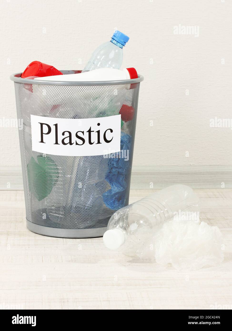 Assorted trash in bucket on room background Stock Photo - Alamy