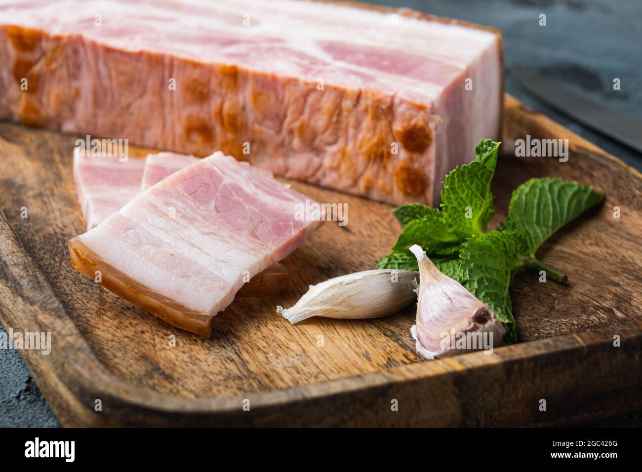 Smoked bacon, whole slab on grey textured background Stock Photo - Alamy