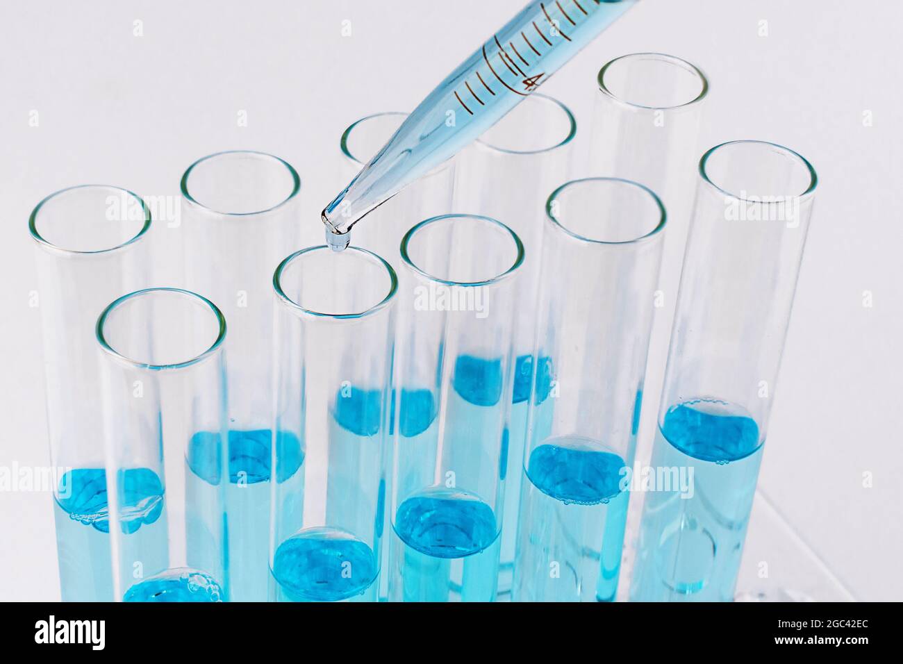 Laboratory test tubes with blue reagent and pipette with drop. Medical ...