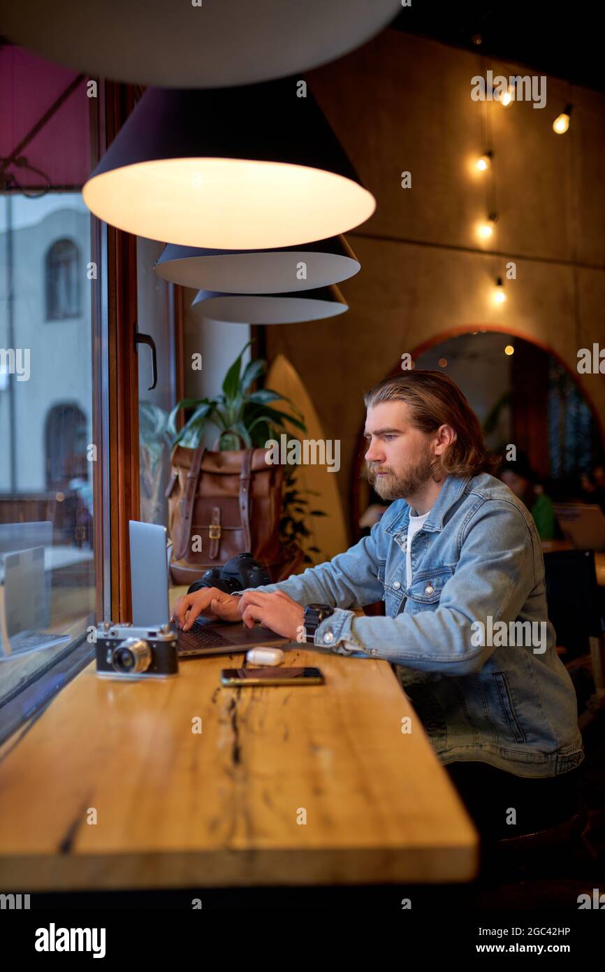 Side View Portrait Of Confident Caucasian Guy In Denim Jacket Working ...