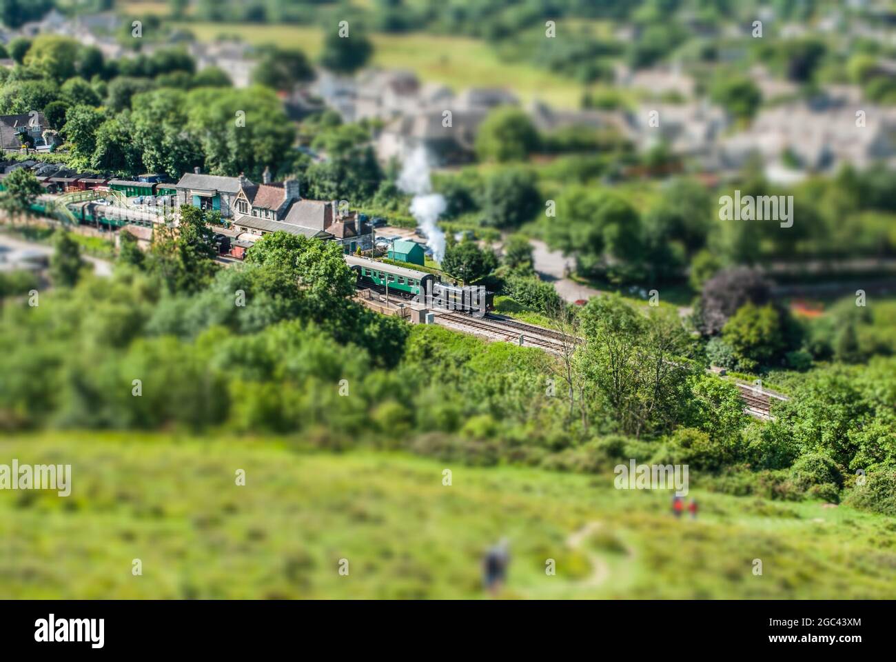 Rail station with Steam Train departing and green fields Stock Photo ...