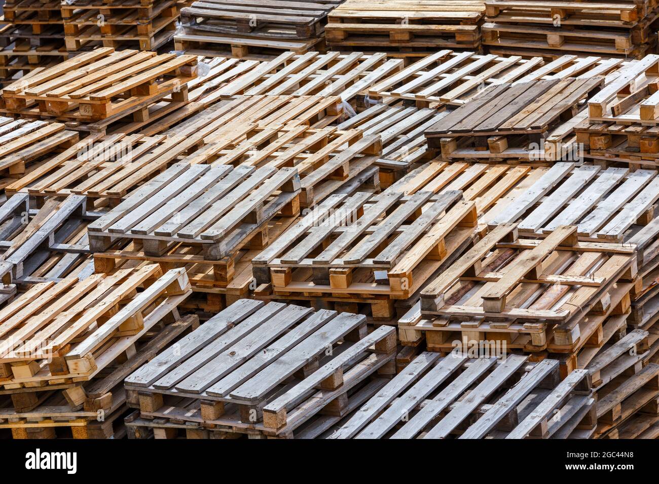 full frame background of used wooden pallet stacks - perspective view ...