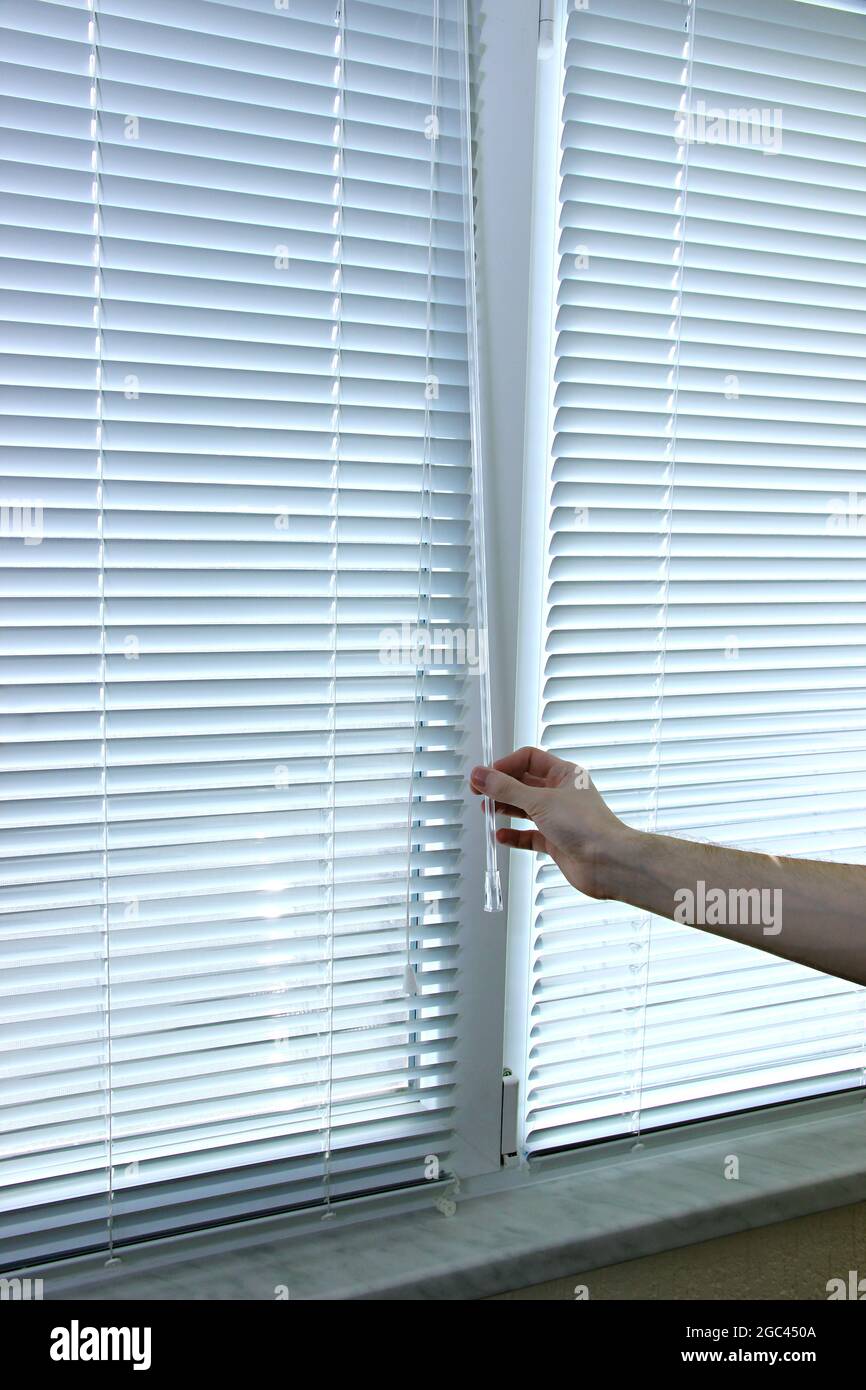 Someone opens blinds Stock Photo - Alamy