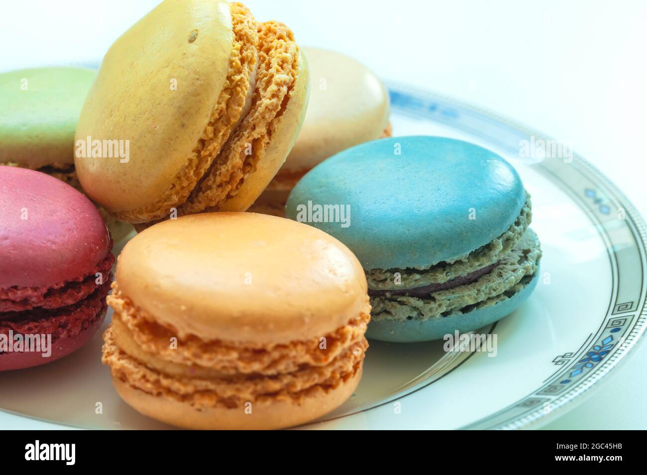 Assorted colorful macaroons on plate in white background Stock Photo ...