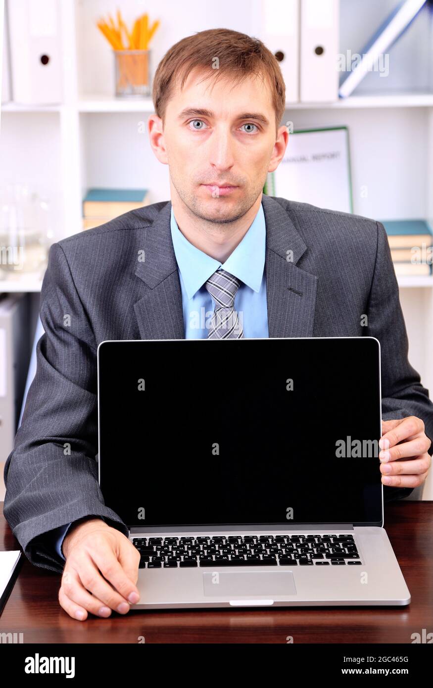 Young businessman with laptop computer facing on his workplace Stock ...