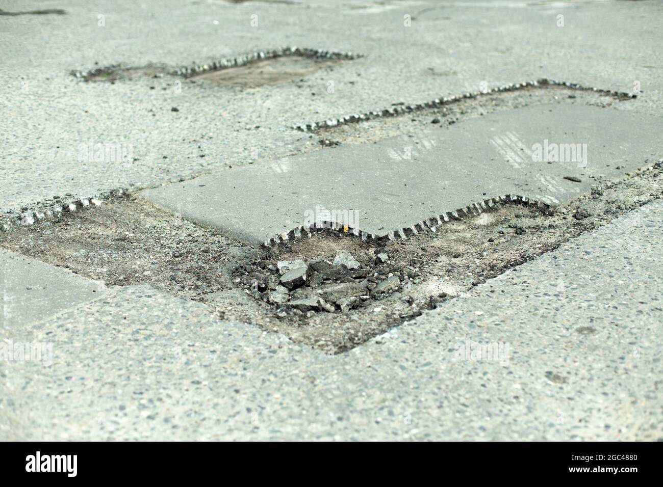 Road repair. Removing holes in the road. A cut piece of asphalt ...