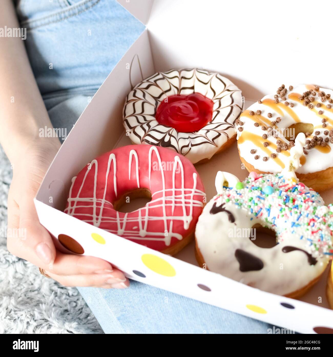 Woman holding box of delicious donuts. Party concept. No diet. Candy ...