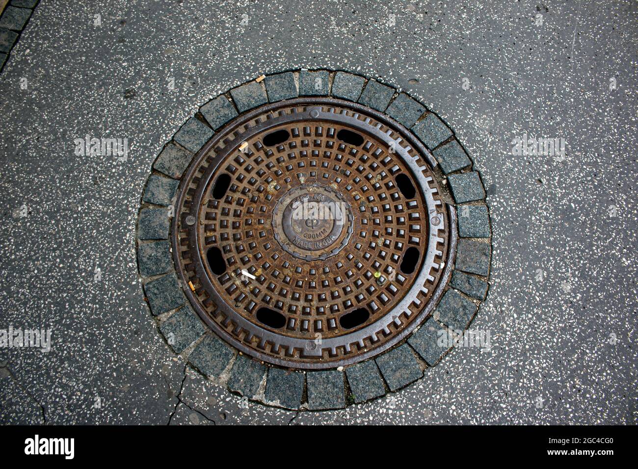 Sewer manhole on the urban asphalt road. Closeup photo Stock Photo - Alamy