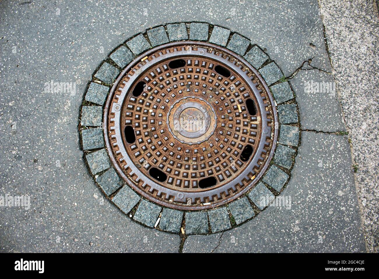 Sewer manhole on the urban asphalt road. Closeup photo Stock Photo - Alamy