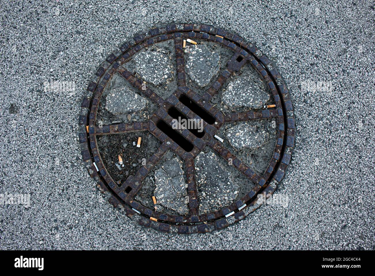 Sewer manhole on the urban asphalt road. Closeup photo Stock Photo - Alamy