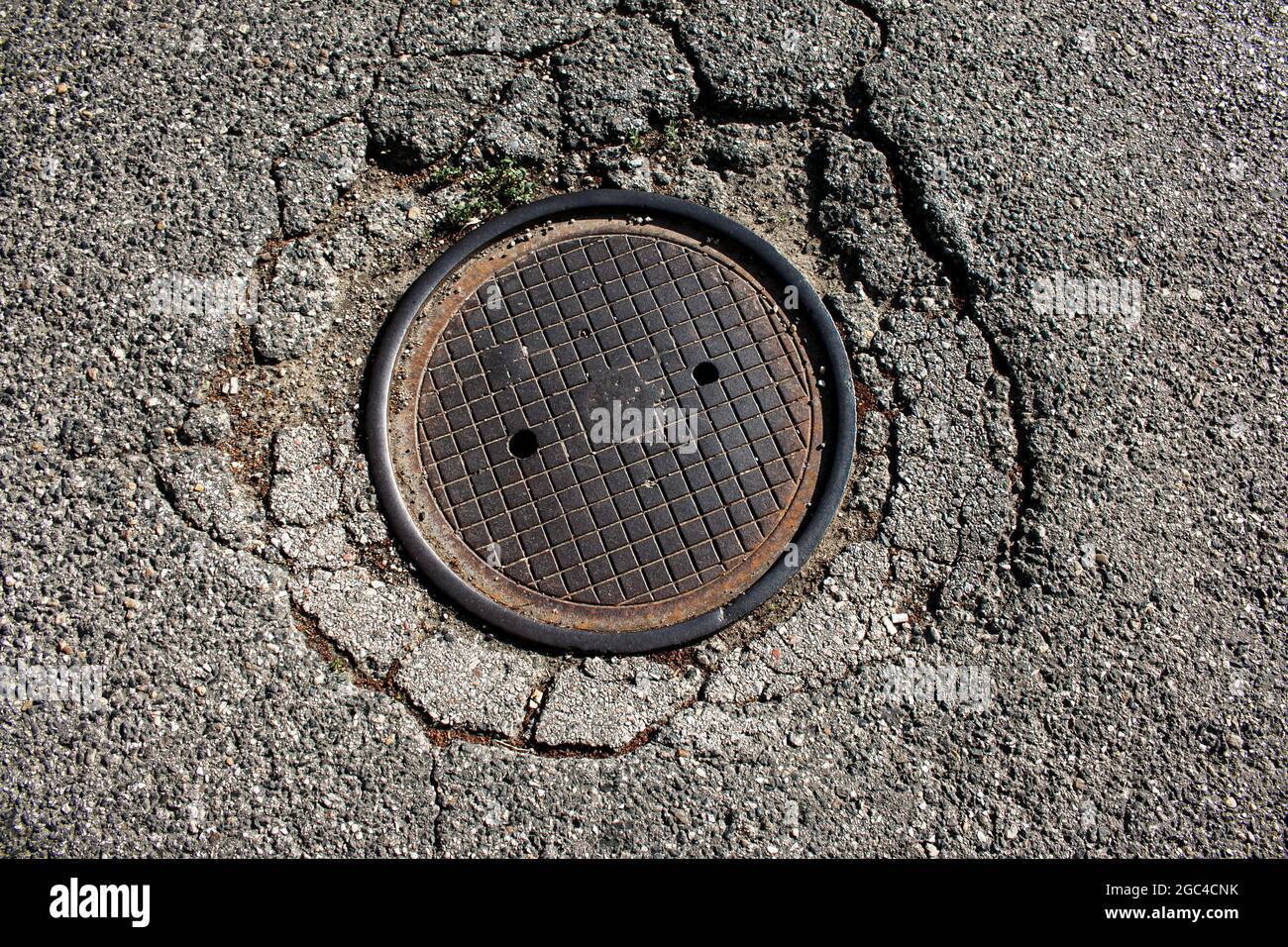Sewer manhole on the urban asphalt road. Closeup photo Stock Photo - Alamy