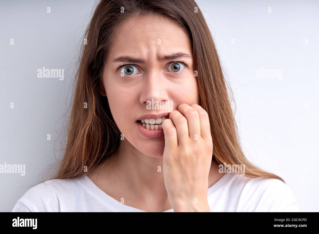 Portrait of worried surprised caucasian woman keeping hands on mouth ...
