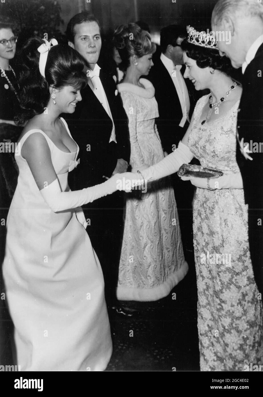 Claudia Cardinale is presented to Her Majesty the Queen on the stage of ...