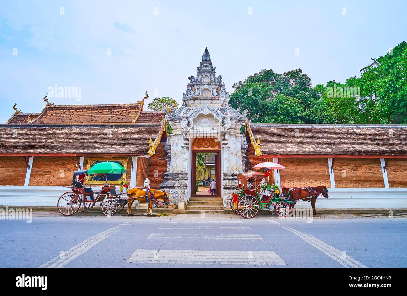 The tall brick rampart and impressive relief Mekong Arch gate of Wat ...