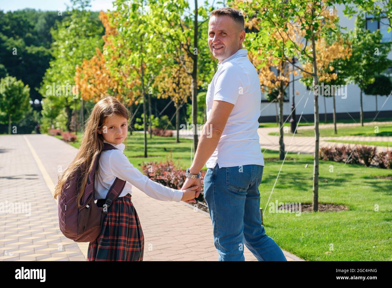 Daughter and father walking together to school down the street Stock ...