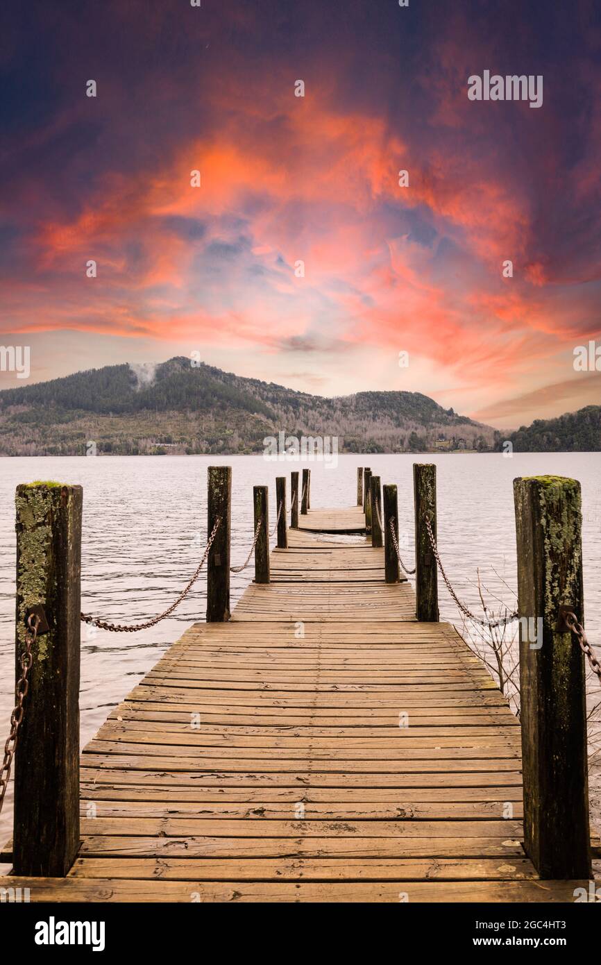 Vertical shot of a wooden dock with fences on the sea under a cloudy ...