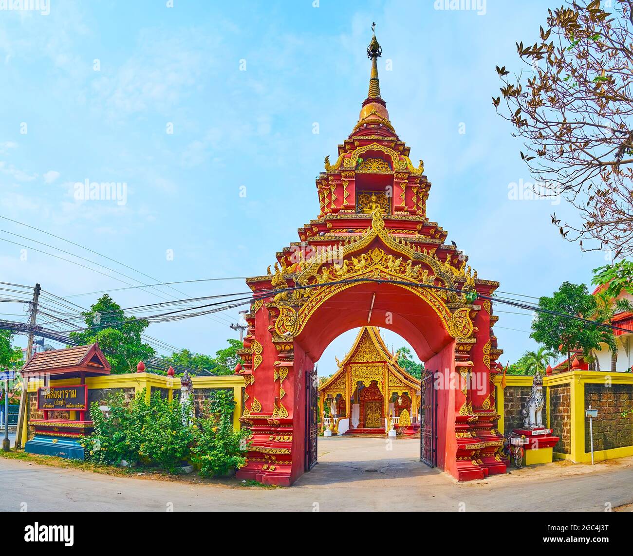 The beautiful red gate of Wat Sangkharam Temple is decorated with ...