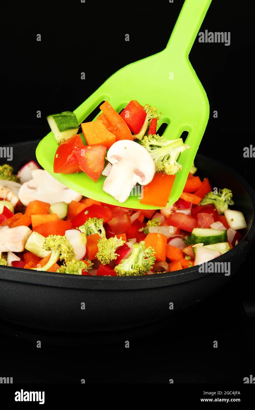 Vegetable ragout in pan, isolated on black Stock Photo - Alamy