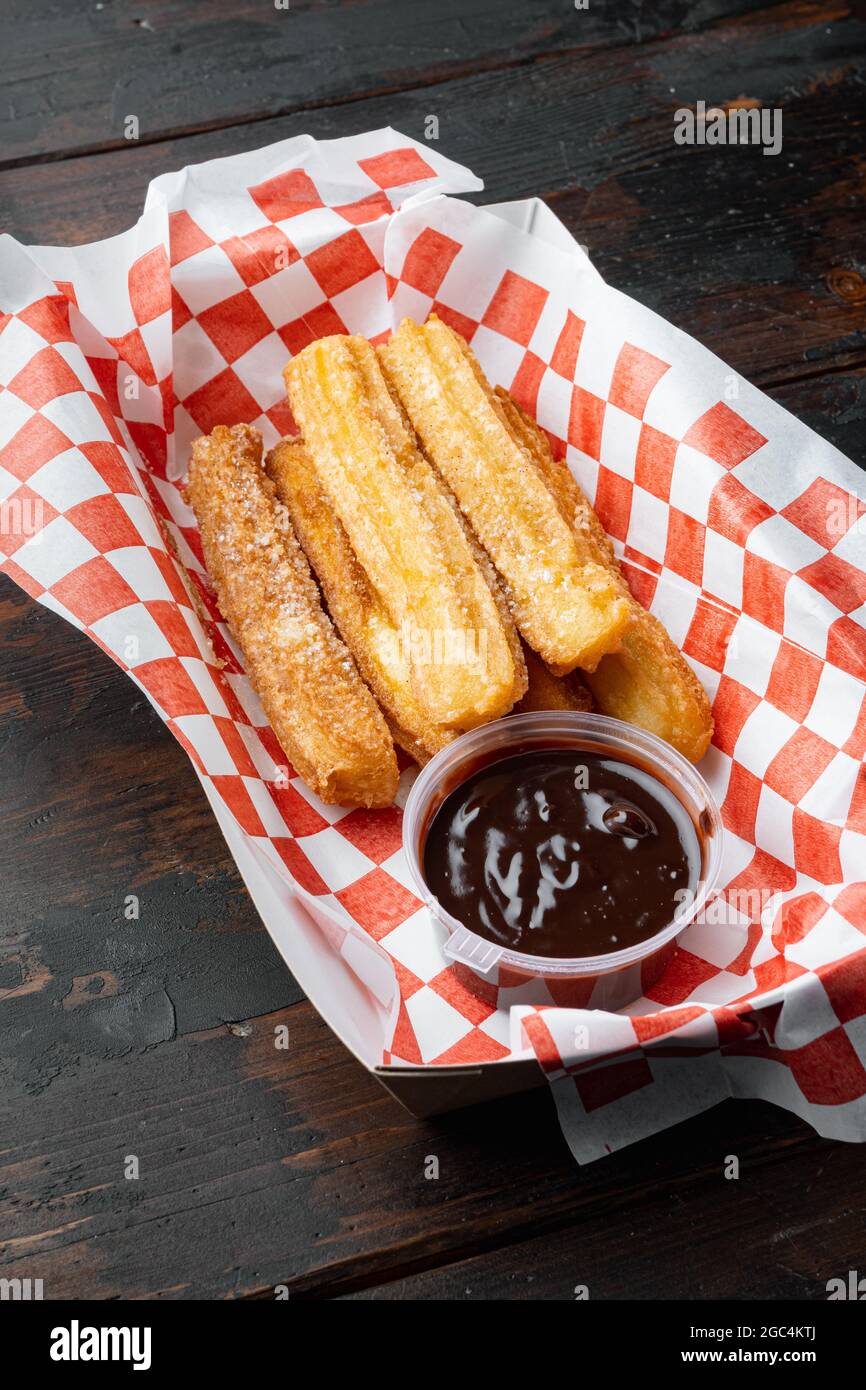 Churros take away set in paper tray, on old dark wooden table ...