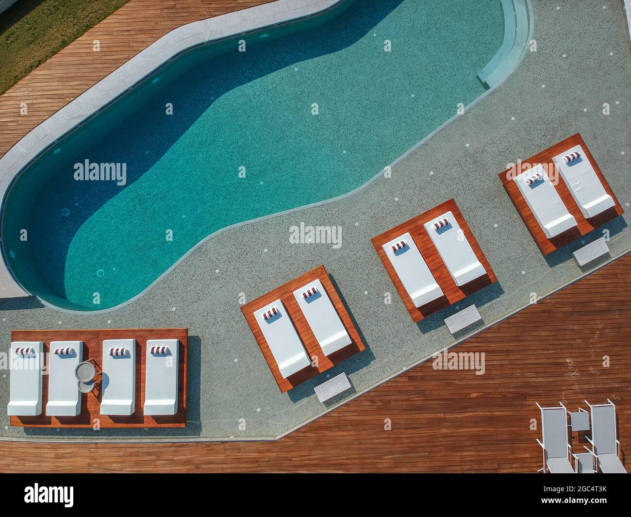 Top down aerial view of hotel swimming pool with crystal blue water and ...