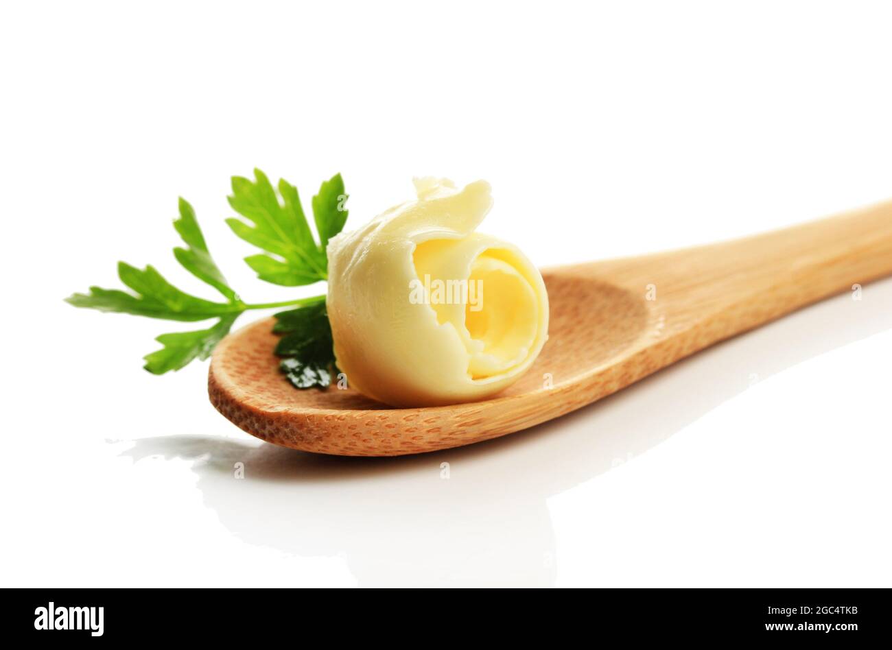Butter curl on wooden spoon, isolated on white Stock Photo - Alamy