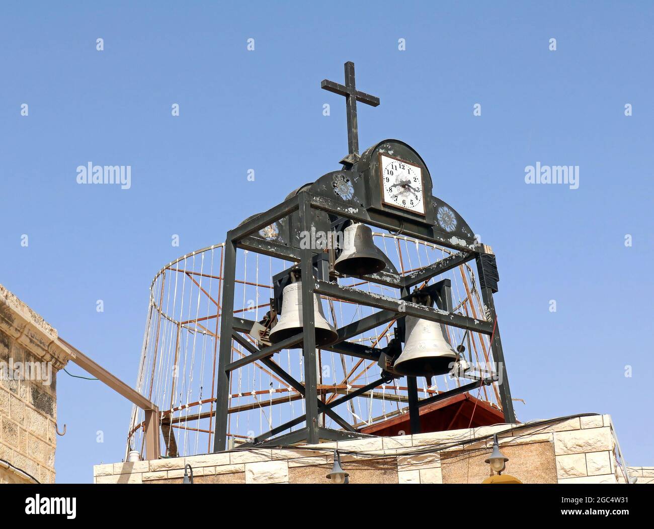 Old ruined church bell inside metal cage on blue sky Stock Photo - Alamy