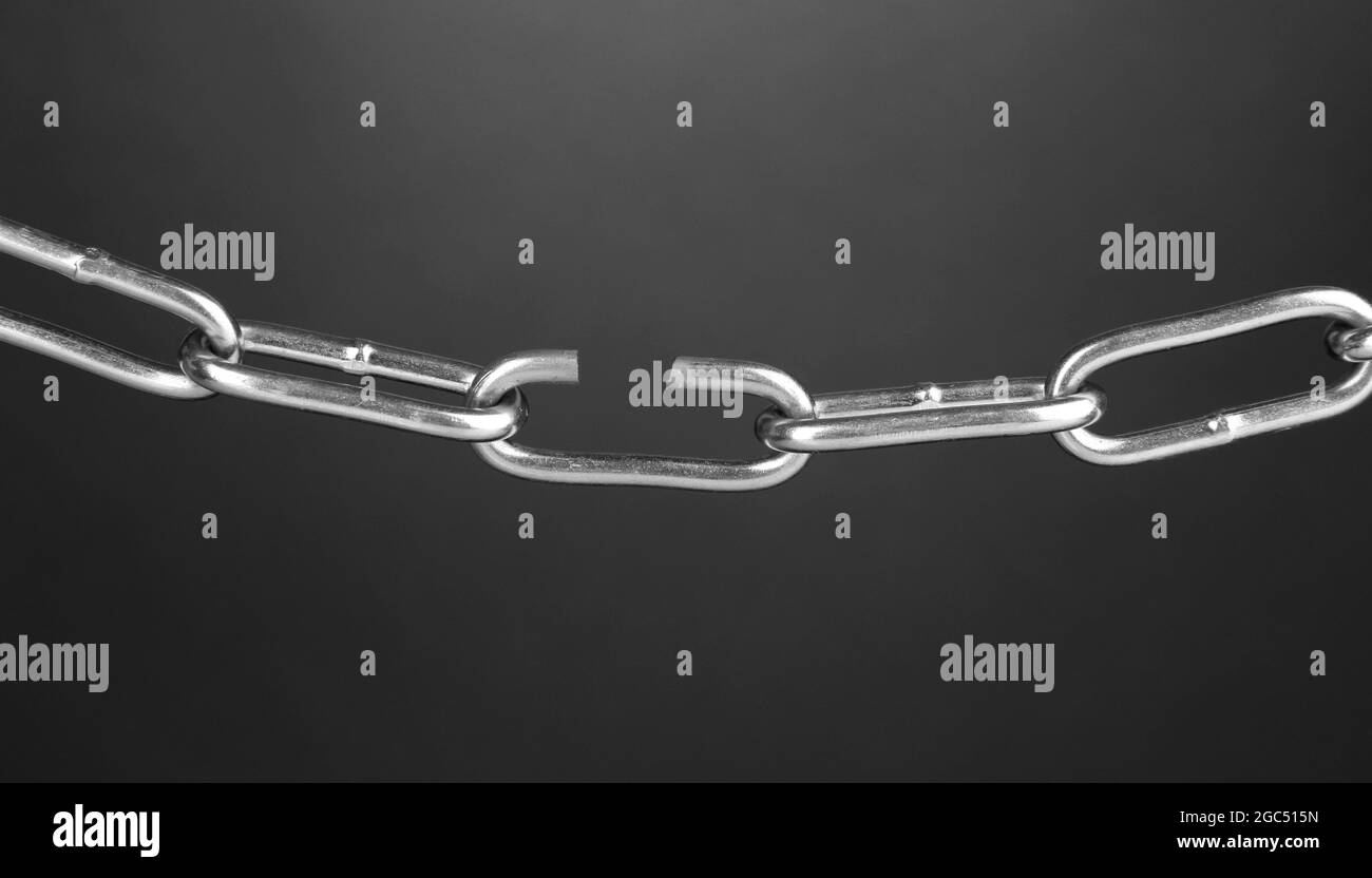 Broken chain on black background Stock Photo - Alamy