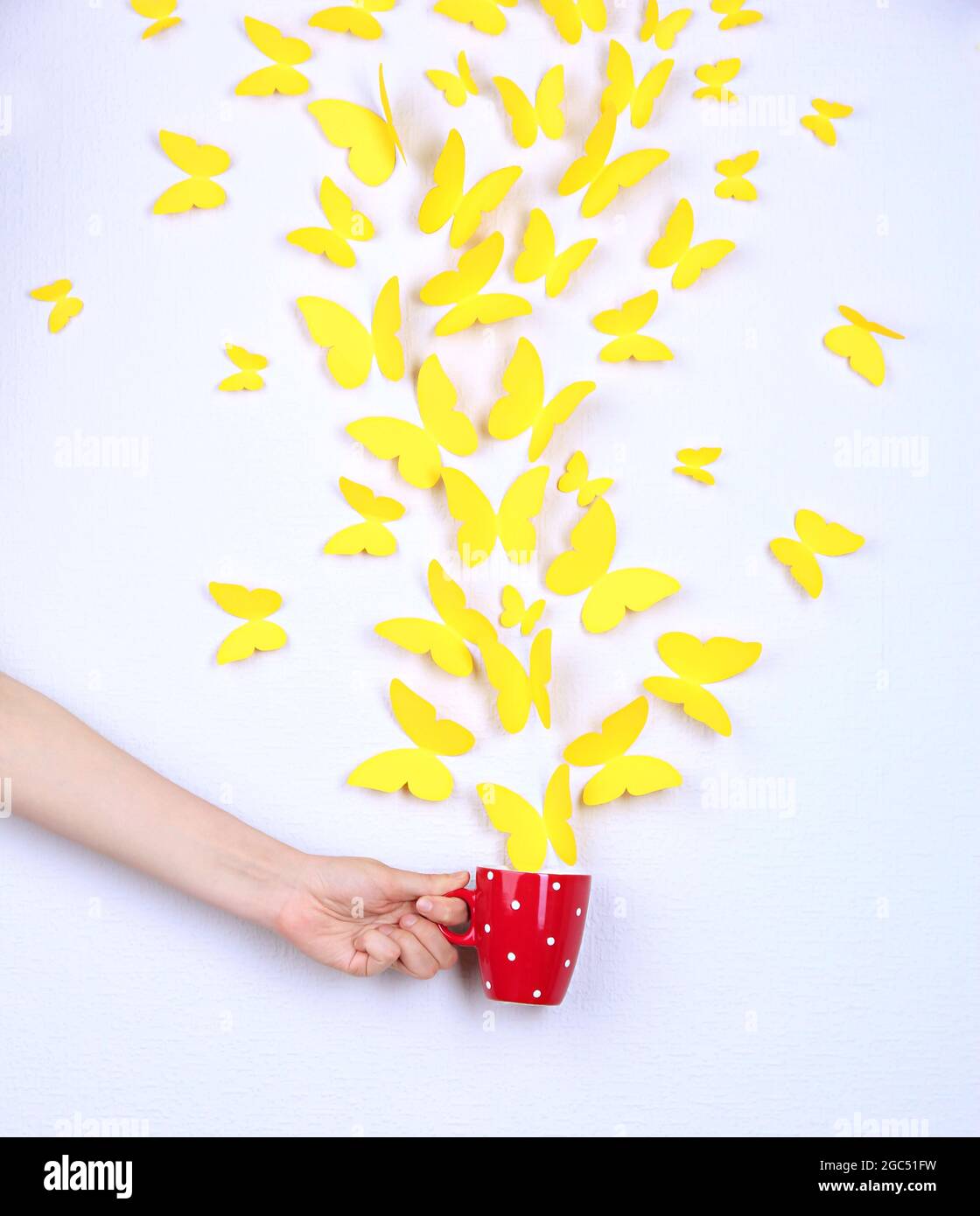 Paper yellow butterflies fly out of cup Stock Photo - Alamy
