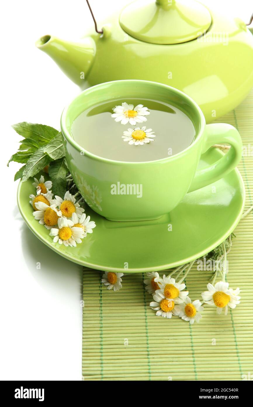 Cup and teapot of herbal tea with wild camomiles and mint, isolated on ...